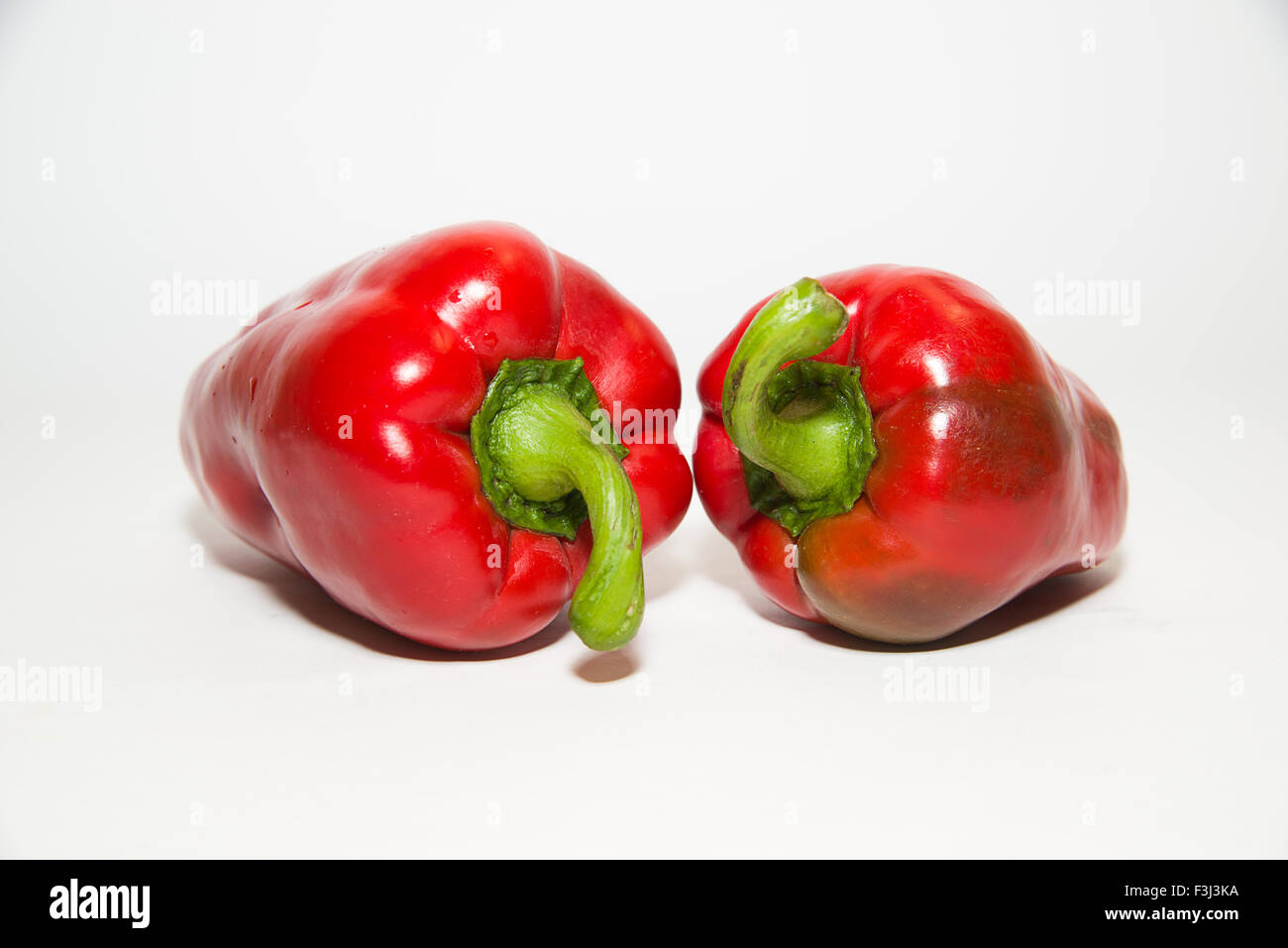 Two red peppers on a white background Stock Photo - Alamy