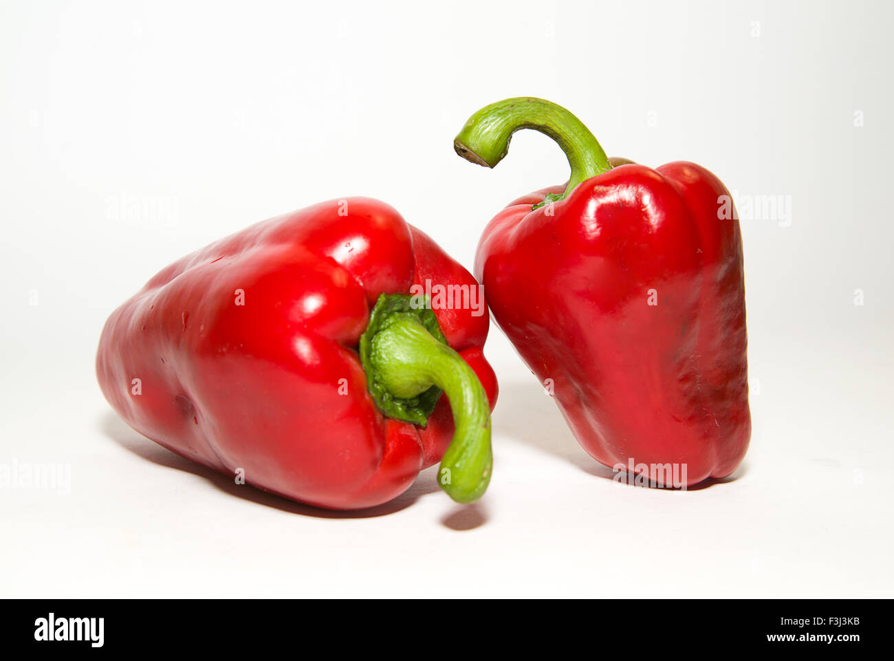 Two red peppers on a white background Stock Photo - Alamy