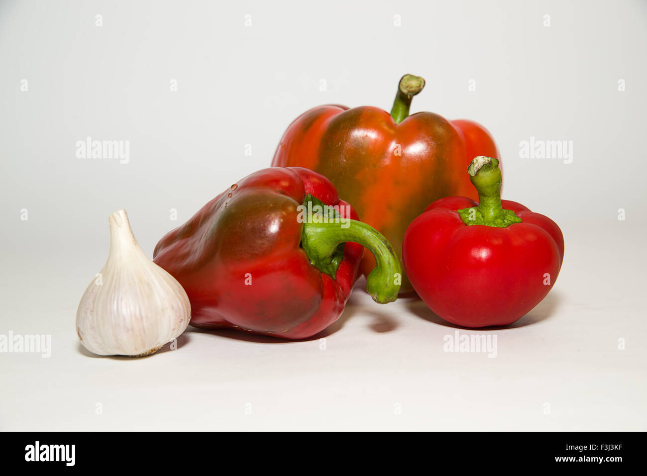 Three red peppers on a white background Stock Photo - Alamy