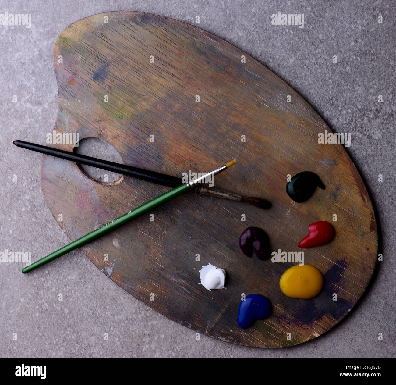 two brushes and colors on a wooden art palette, gray background Stock ...
