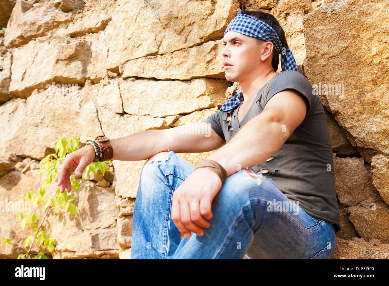 Handsome man sitting on stone hi-res stock photography and images - Alamy