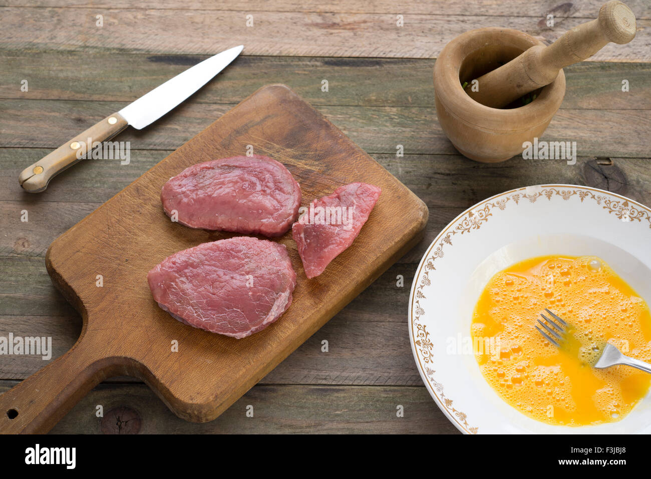 Preparing three servings of meat in egg batter Stock Photo - Alamy
