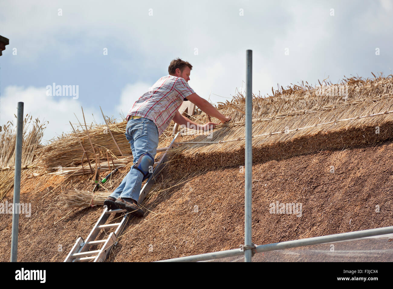 Man thatching a roof Stock Photo - Alamy