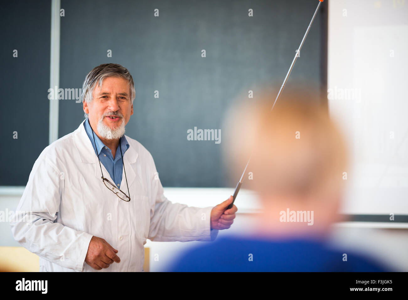 Senior chemistry professor giving a lecture in front of classroom full ...