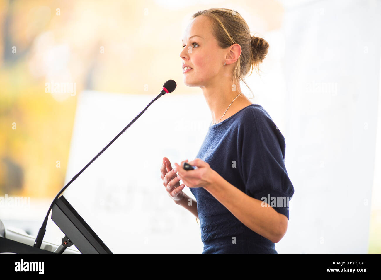 Pretty, young business woman giving a presentation in a conference ...