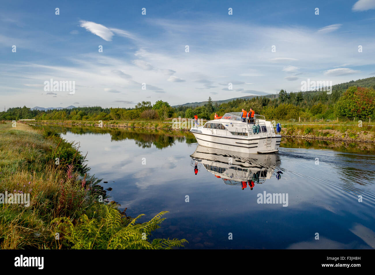 Family on a small motor cruiser cruising along the Caledonian Canal in ...