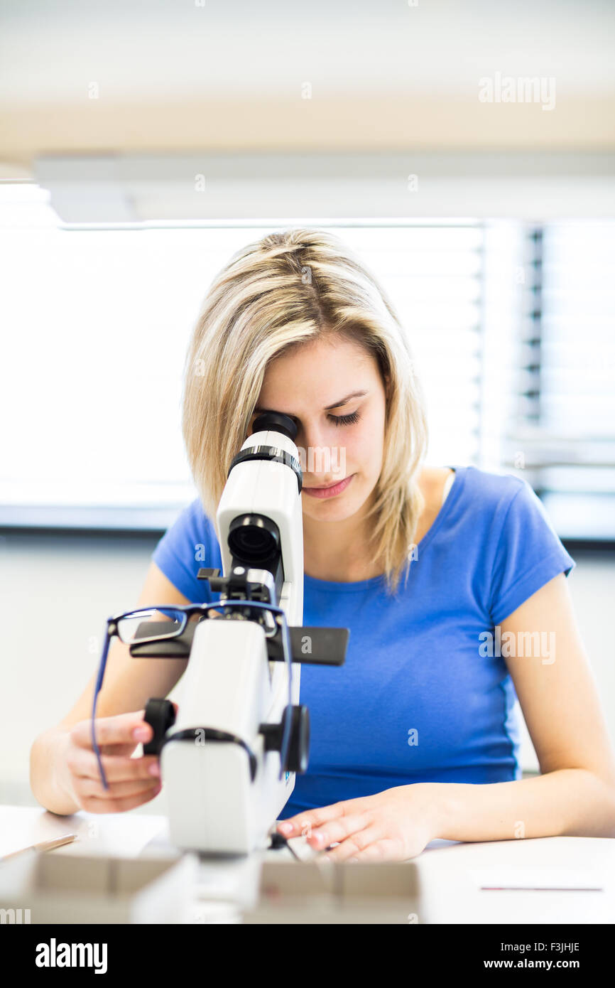 Pretty, female optometrist measuring newly made glasses - veryfing it ...