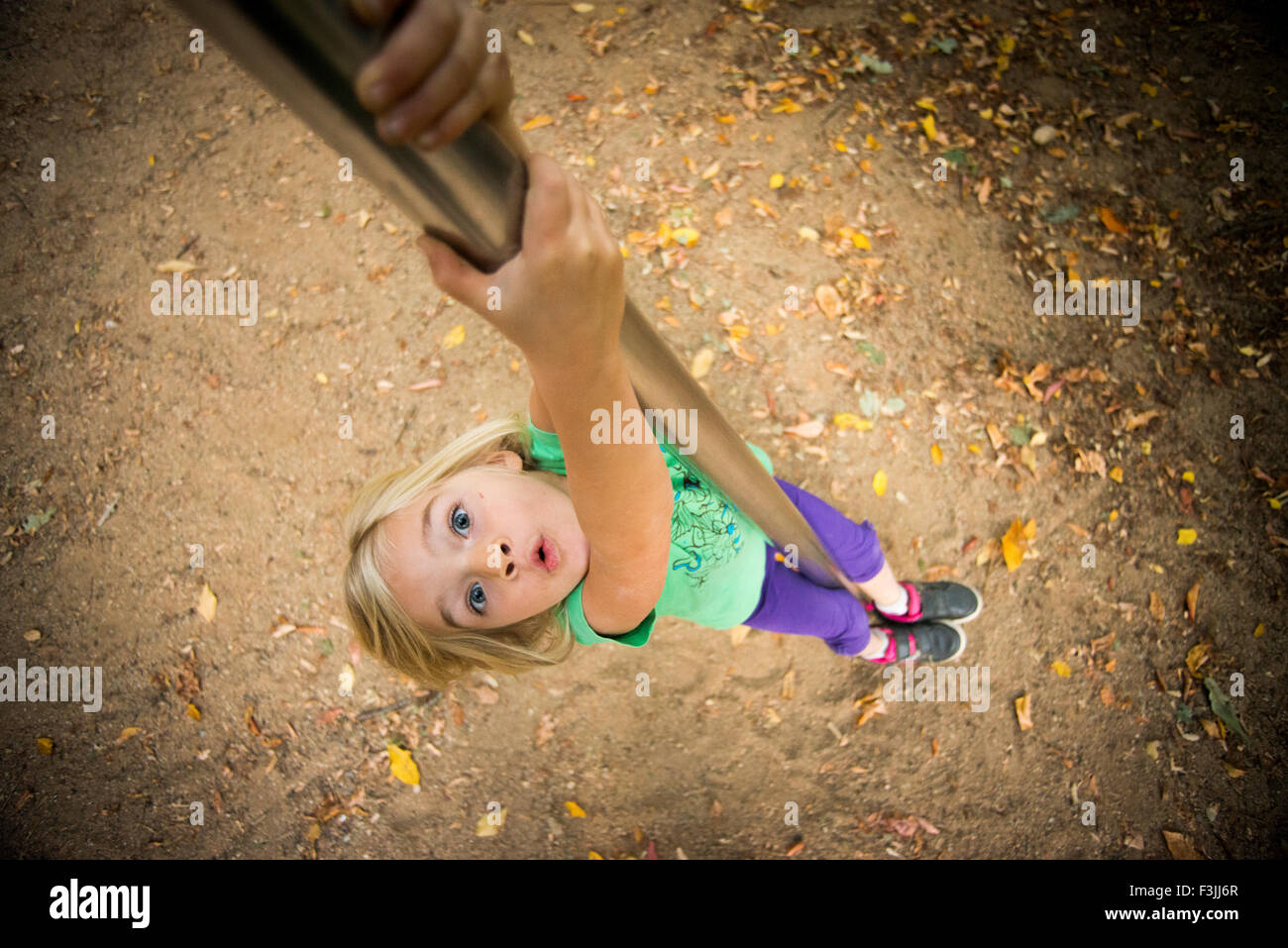 Child Girl climbs on a pole at the playground, sliding, kid playing ...
