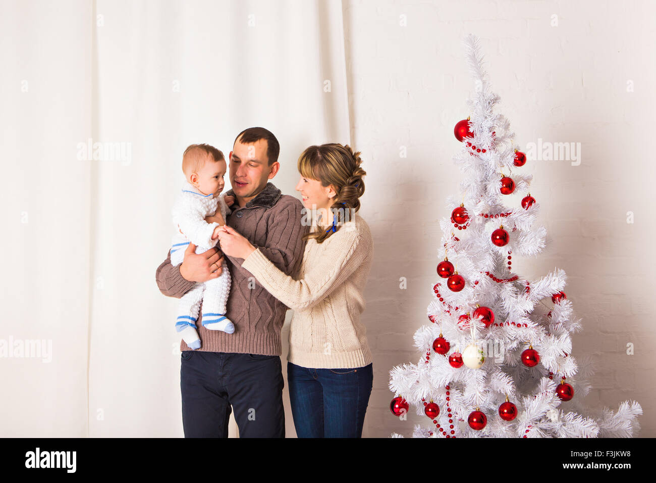 Happy family and Christmas tree Stock Photo - Alamy
