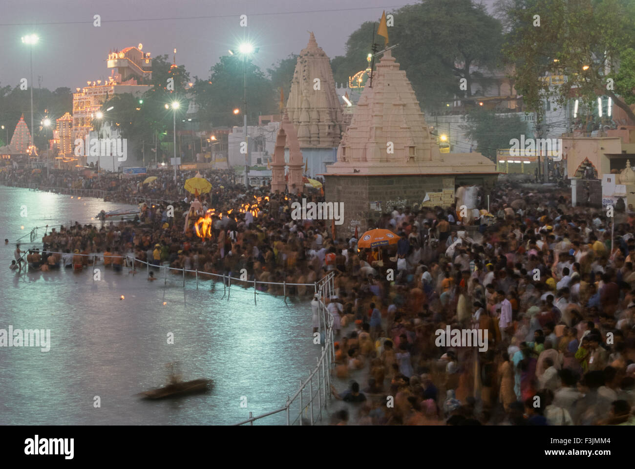 Bathing pilgrims thronging the ghats of the Shipra River during evening ...