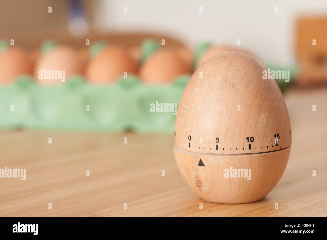 Egg timer with a carton of fresh eggs in the background Stock Photo - Alamy