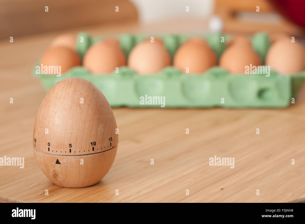 Egg timer with a carton of fresh eggs in the background Stock Photo - Alamy