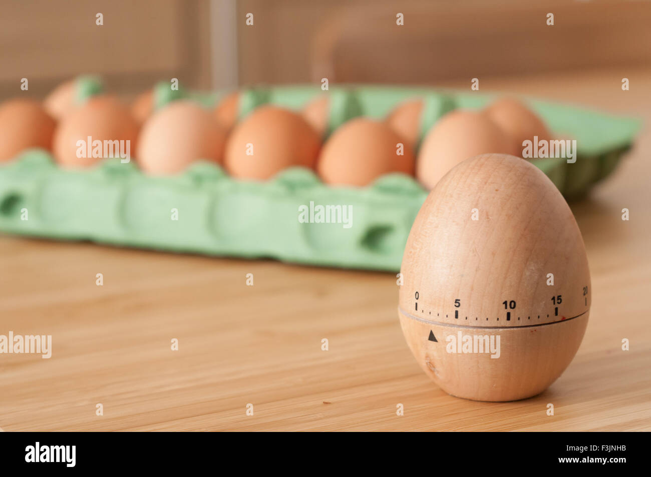 Egg timer with a carton of fresh eggs in the background Stock Photo - Alamy