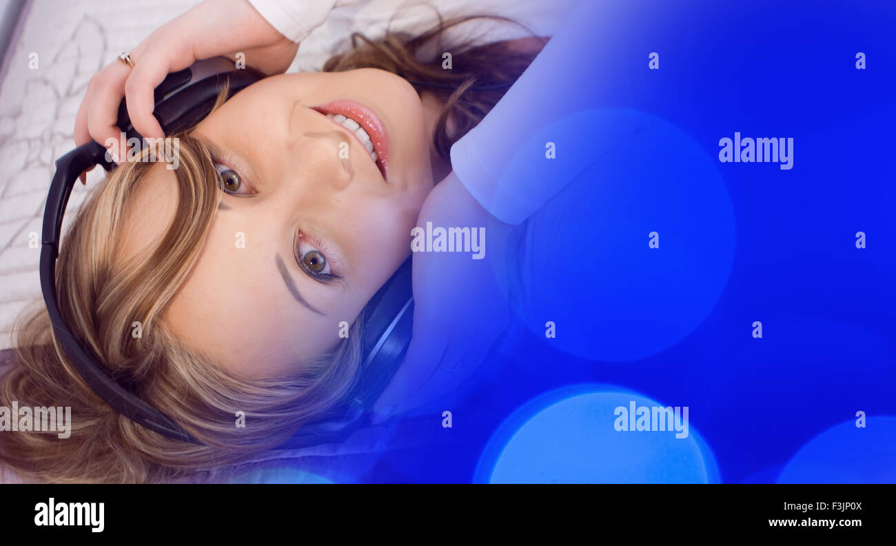 Title concept, pretty woman in large headphones listening to music ...
