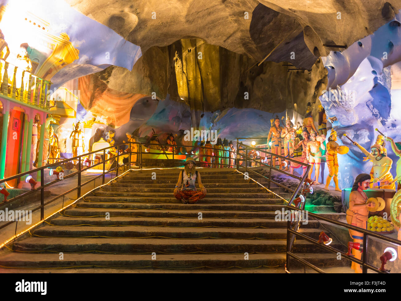 Young woman with backpack exploring cave with torch Stock Photo - Alamy