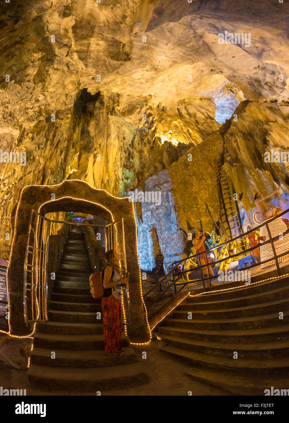 Young woman with backpack exploring cave with torch Stock Photo - Alamy
