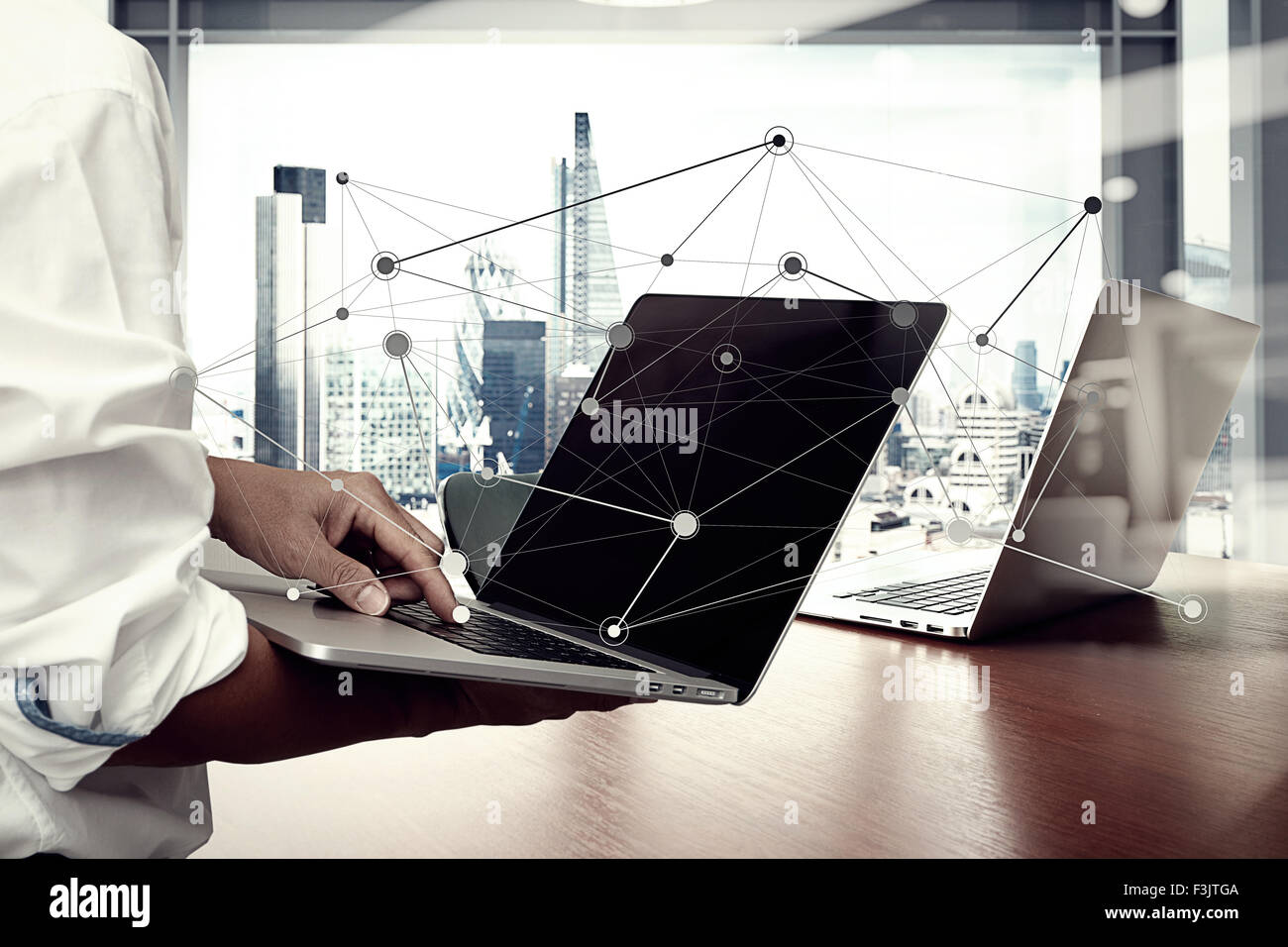 business man hand working on laptop computer on wooden desk as concept ...