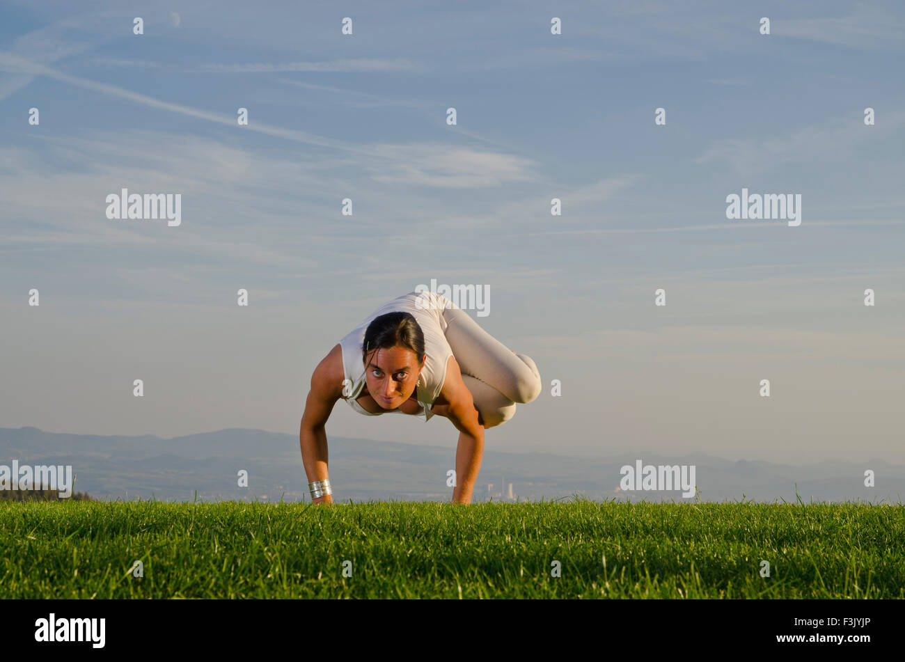 Young woman practising Hatha-Yoga outdoor, showing the pose parshva ...