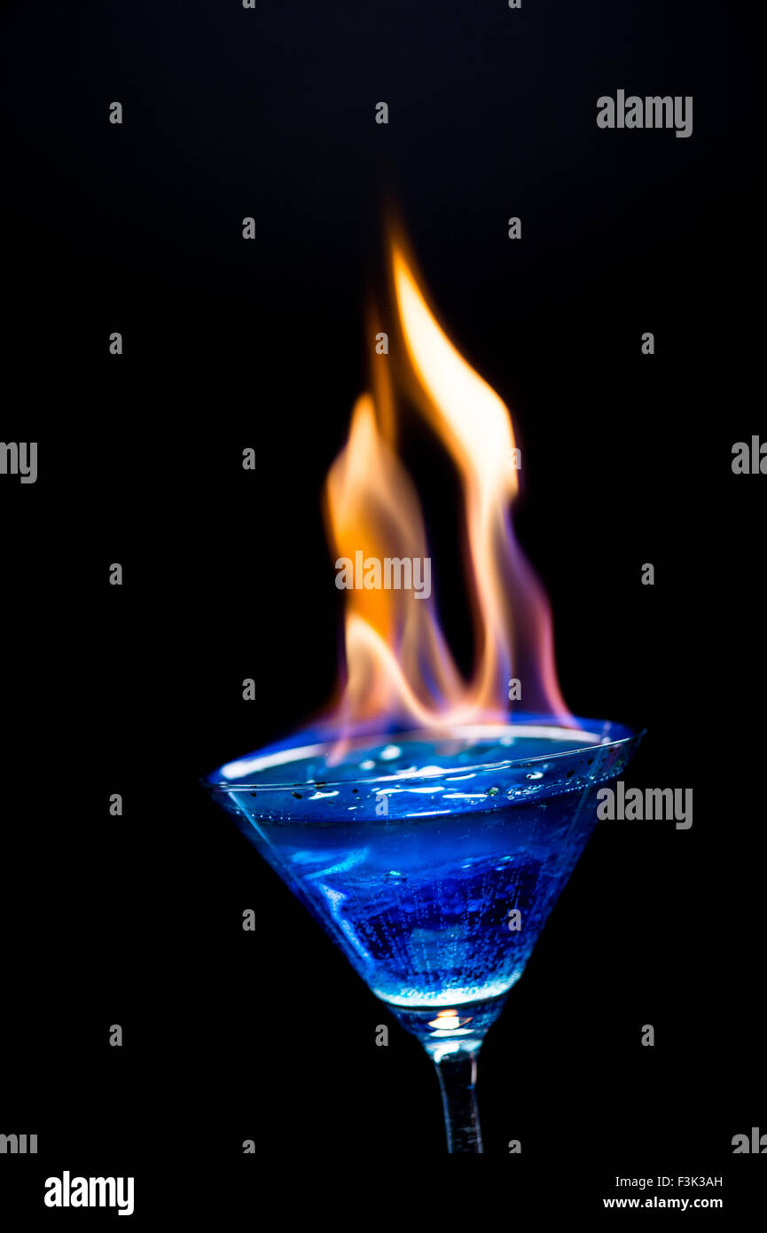 Fire blowing out of blue lagoon glass/close-up with black background ...