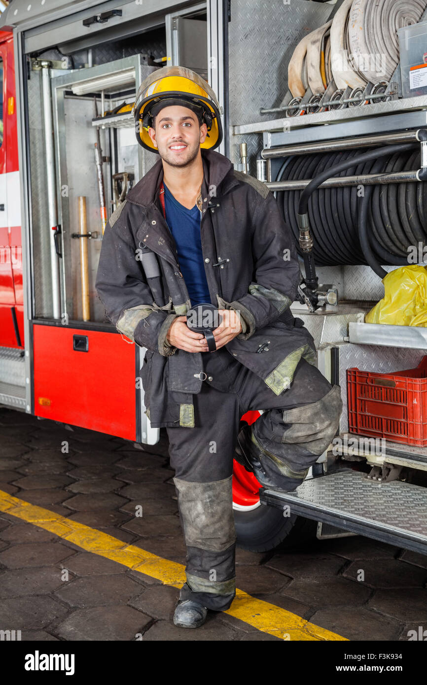 Smiling Fireman Standing By Truck At Fire Station Stock Photo - Alamy
