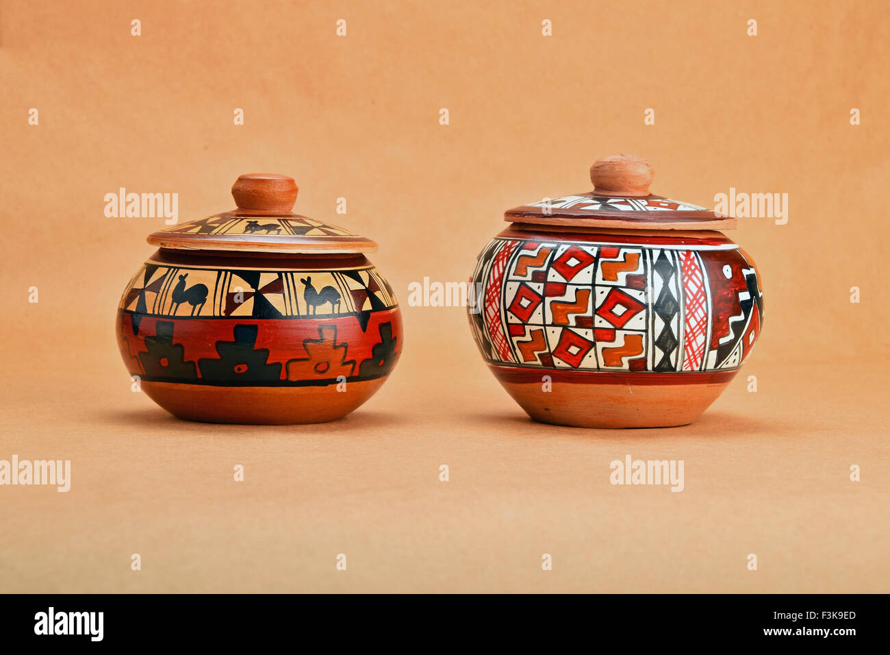 Two painted handmade traditional Latin American ceramic pot with closed ...