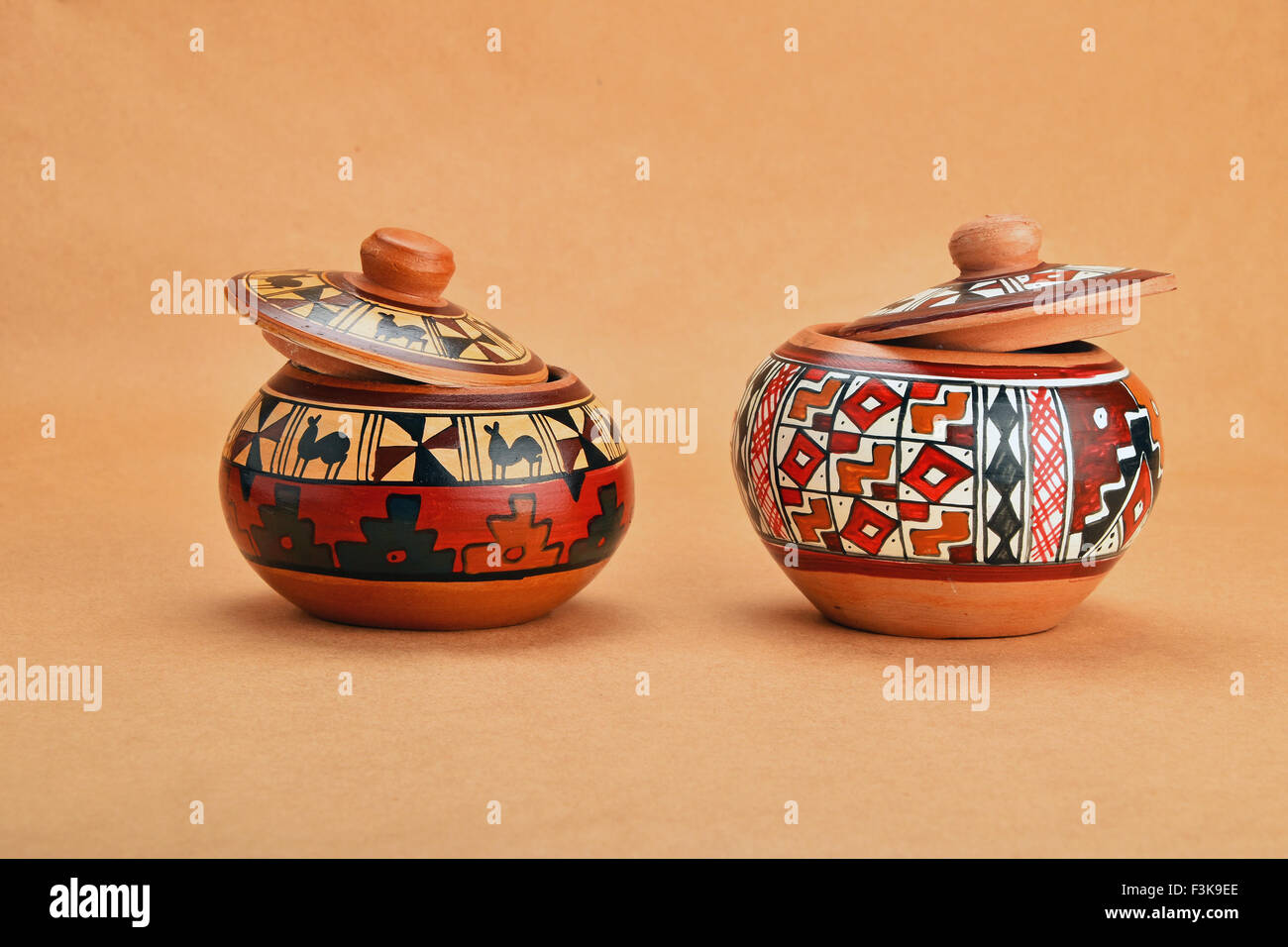Two painted handmade traditional Latin American ceramic pot with closed ...