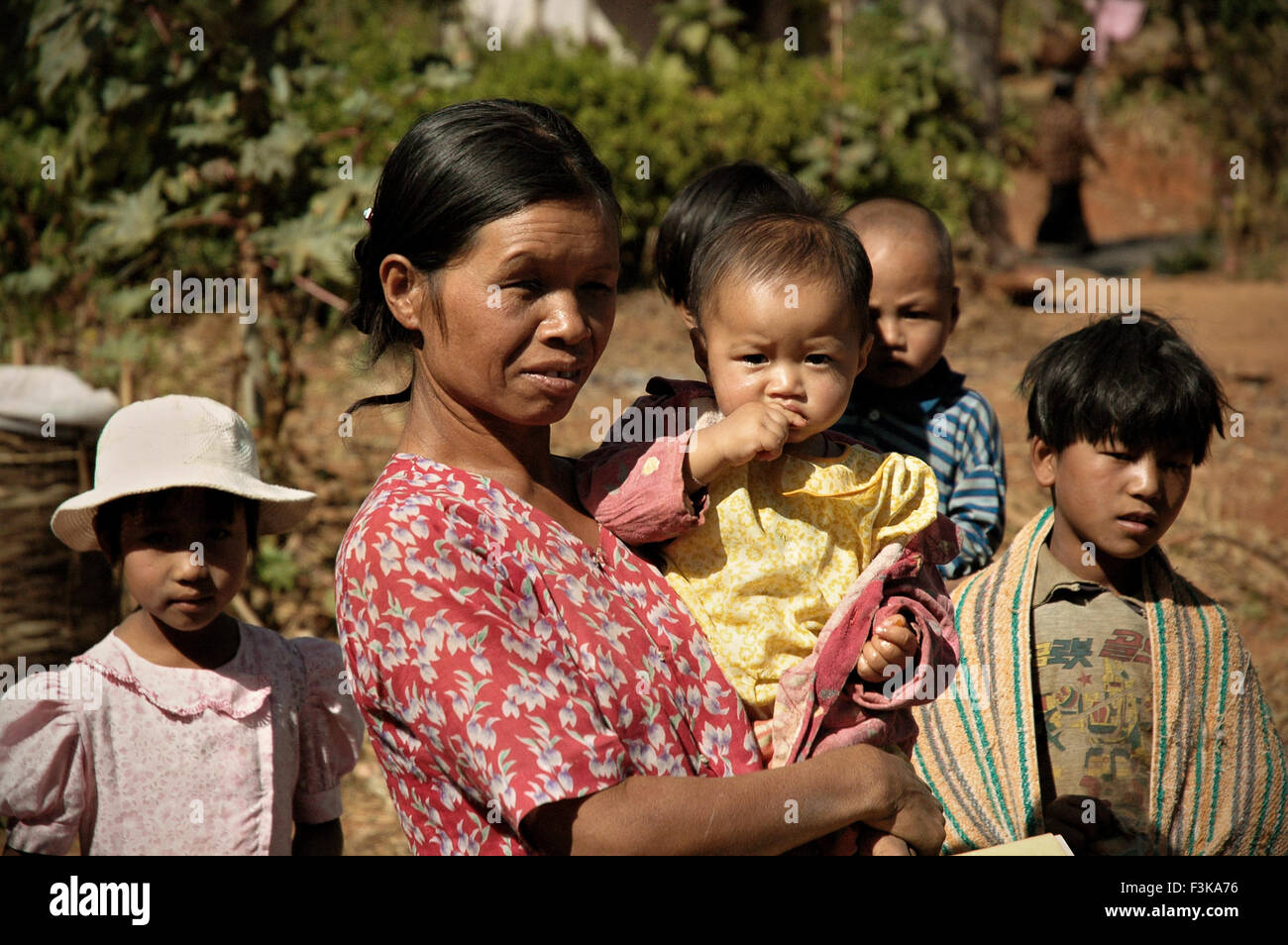 Burmese woman carrying a baby girl with other kids around, Shan State ...