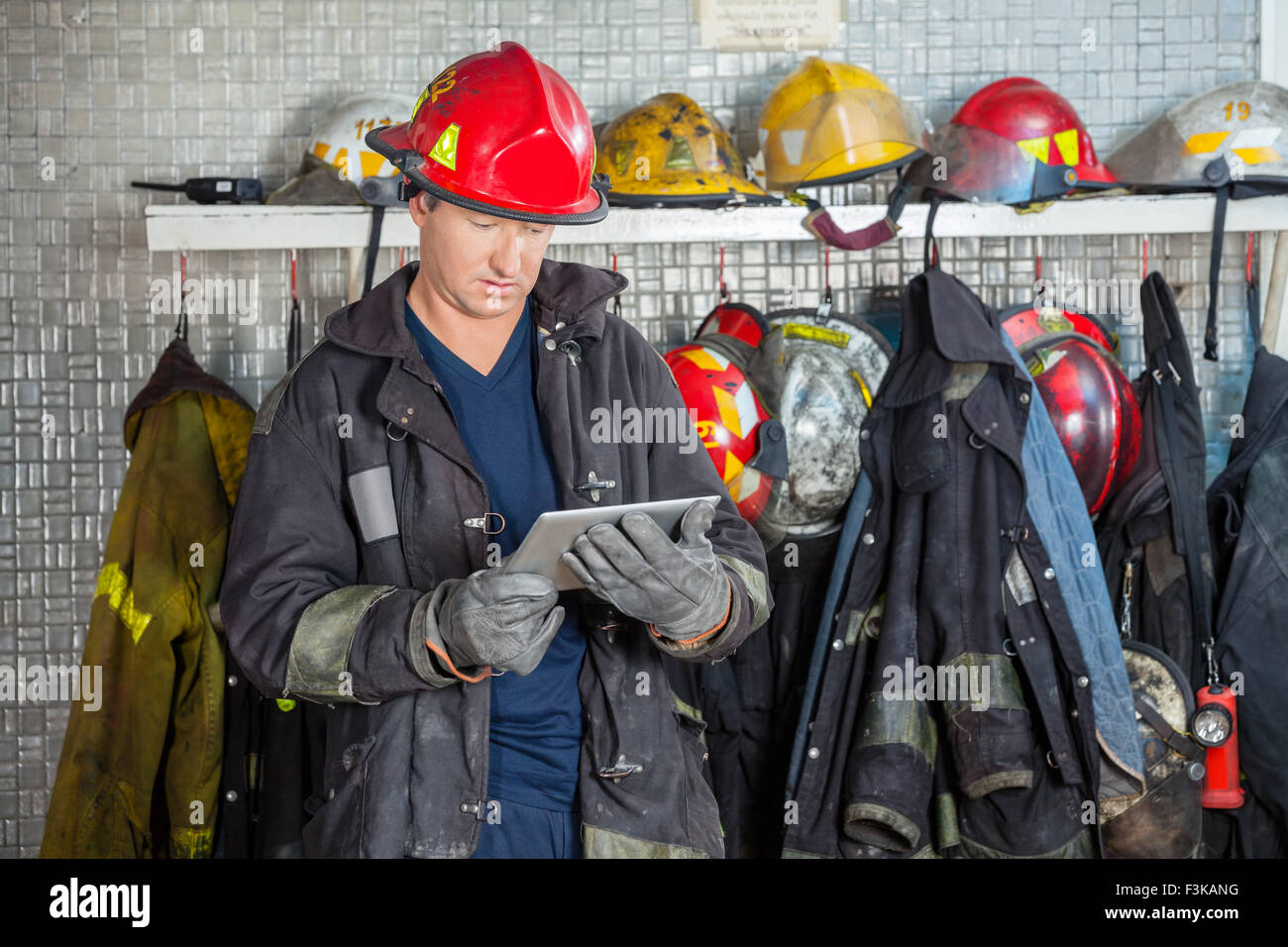 Fireman Using Digital Tablet At Fire Station Stock Photo - Alamy