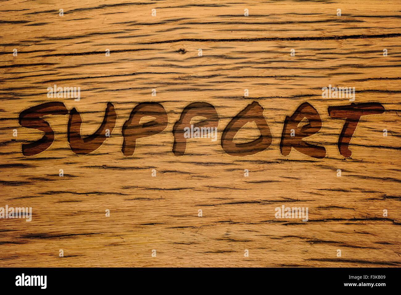 Concept support text carved into wood. Spotlight effect on message on ...