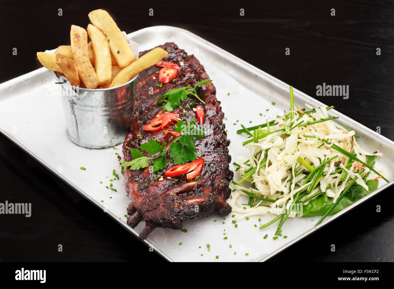 BBQ Rack of Ribs with salted fries and Asian slaw Stock Photo - Alamy