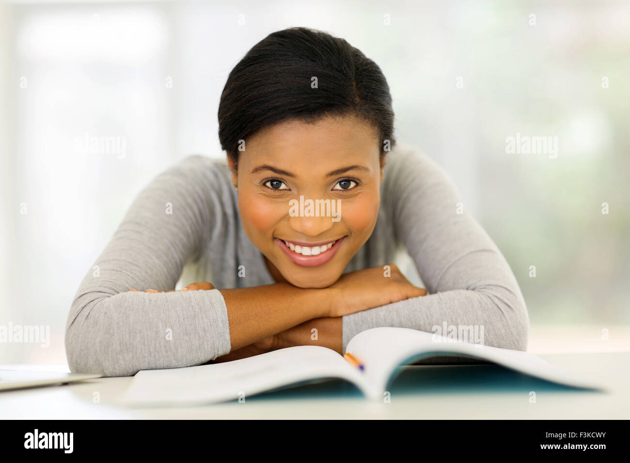 African girl smiling book desk hi-res stock photography and images - Alamy