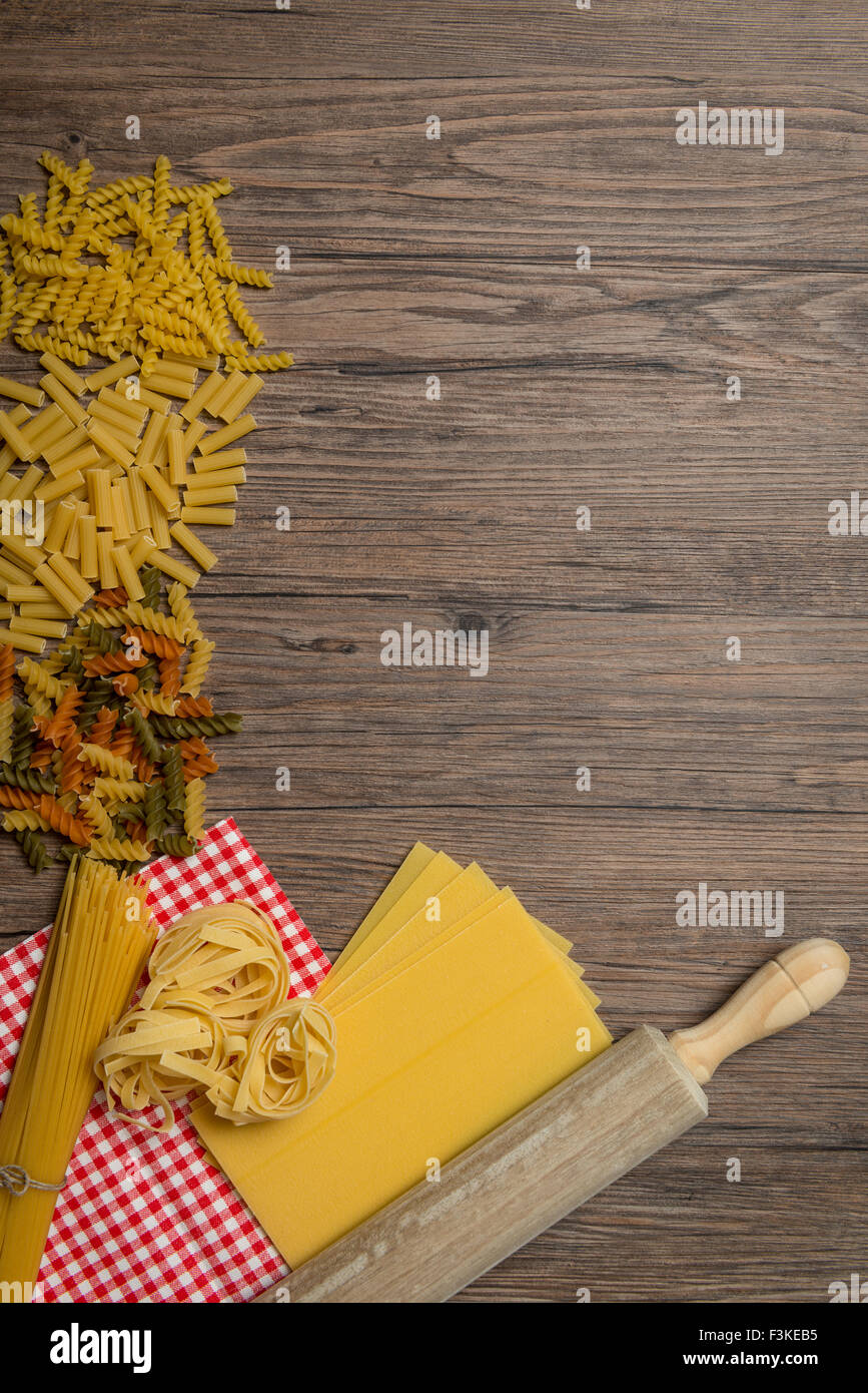 Uncooked italian pasta, brown wood table background Stock Photo - Alamy