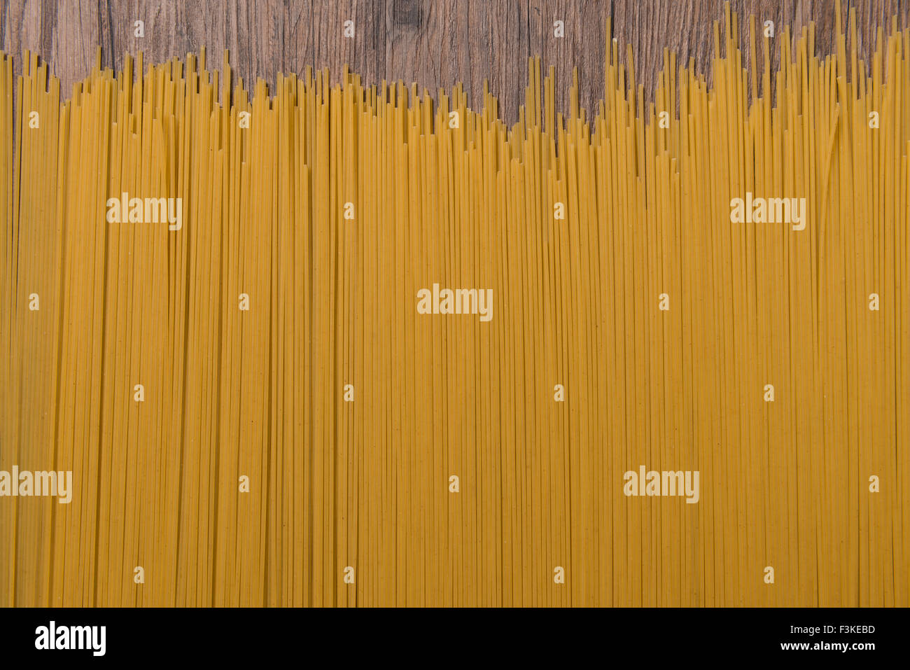 Uncooked italian pasta, brown wood table background Stock Photo - Alamy