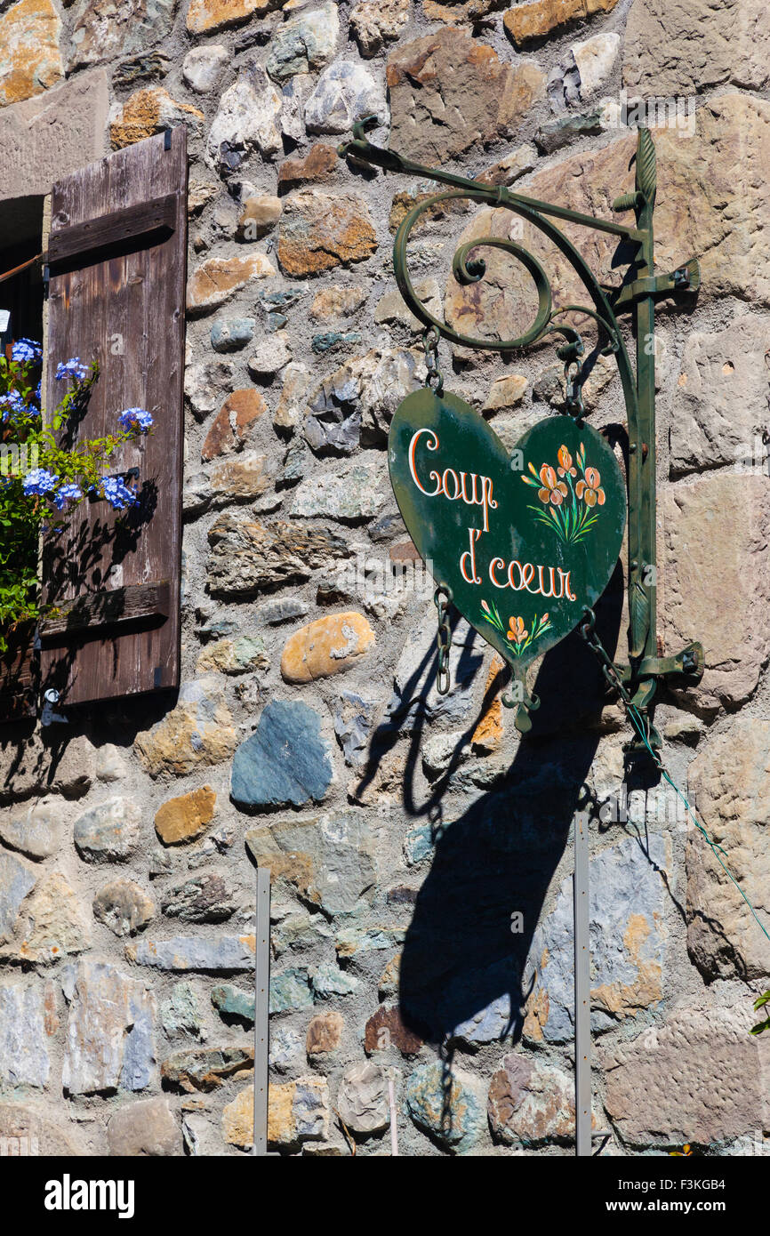 Wrought iron sign hanging on a stone house wall in the village of ...