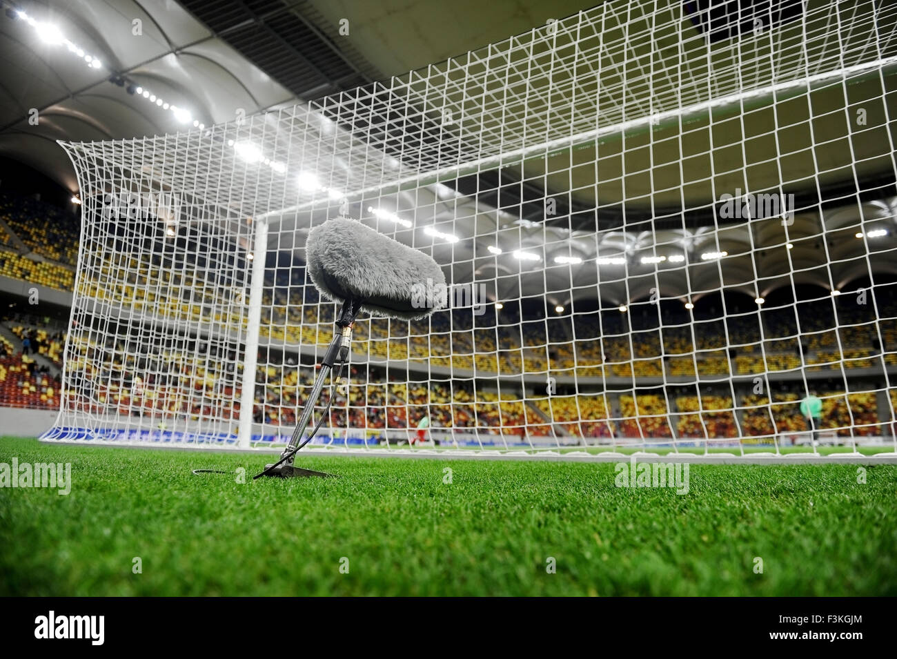 Big and furry sport microphone on a soccer field behind the goal net ...