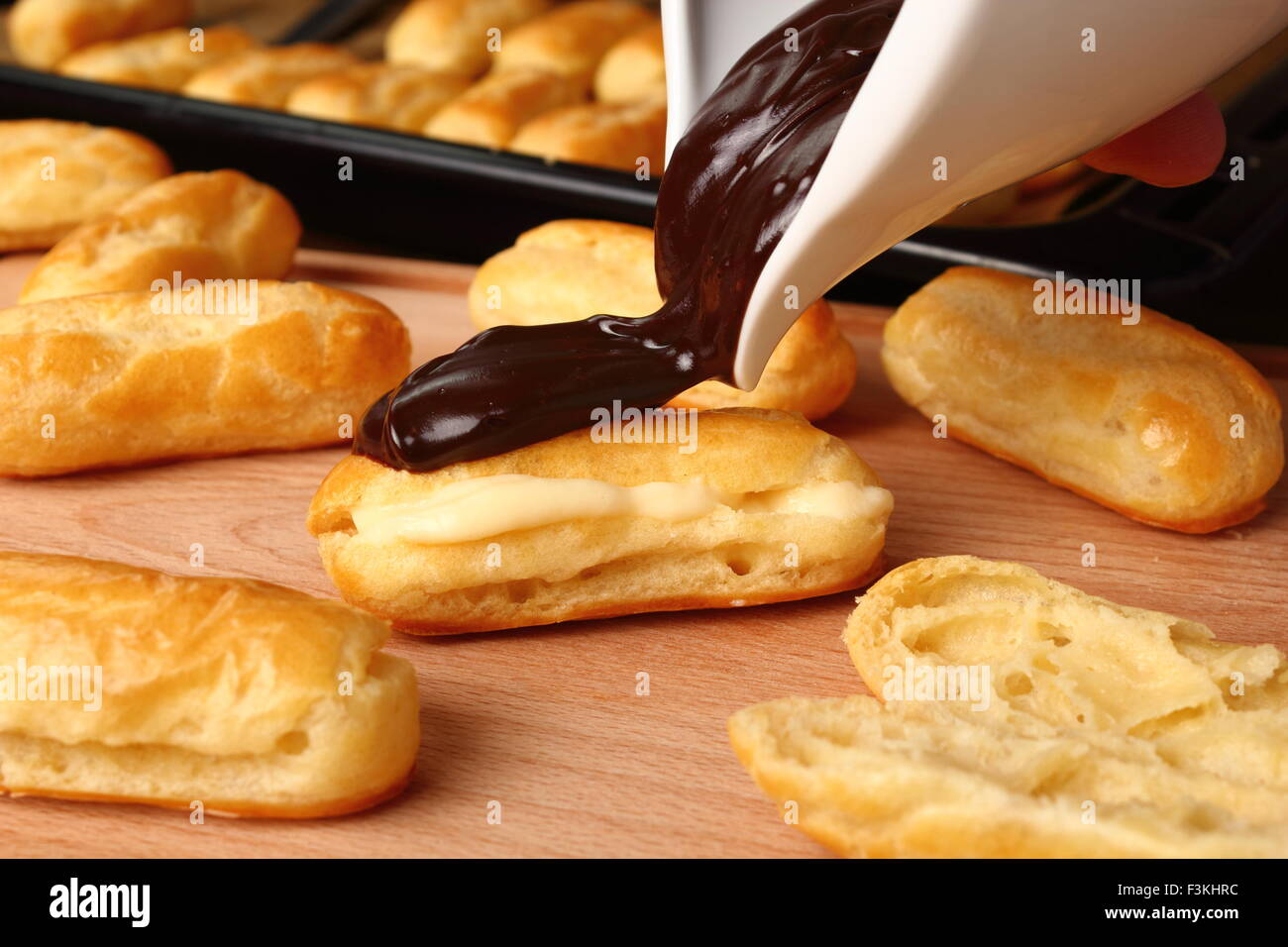 Pouring melted chocolate. Making Eclair Stock Photo - Alamy
