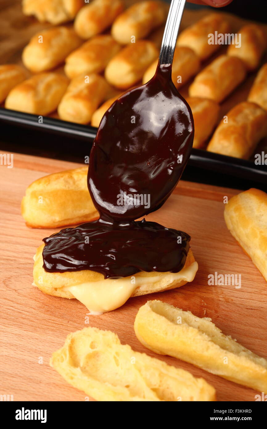 Pouring melted chocolate. Making Eclair Stock Photo - Alamy