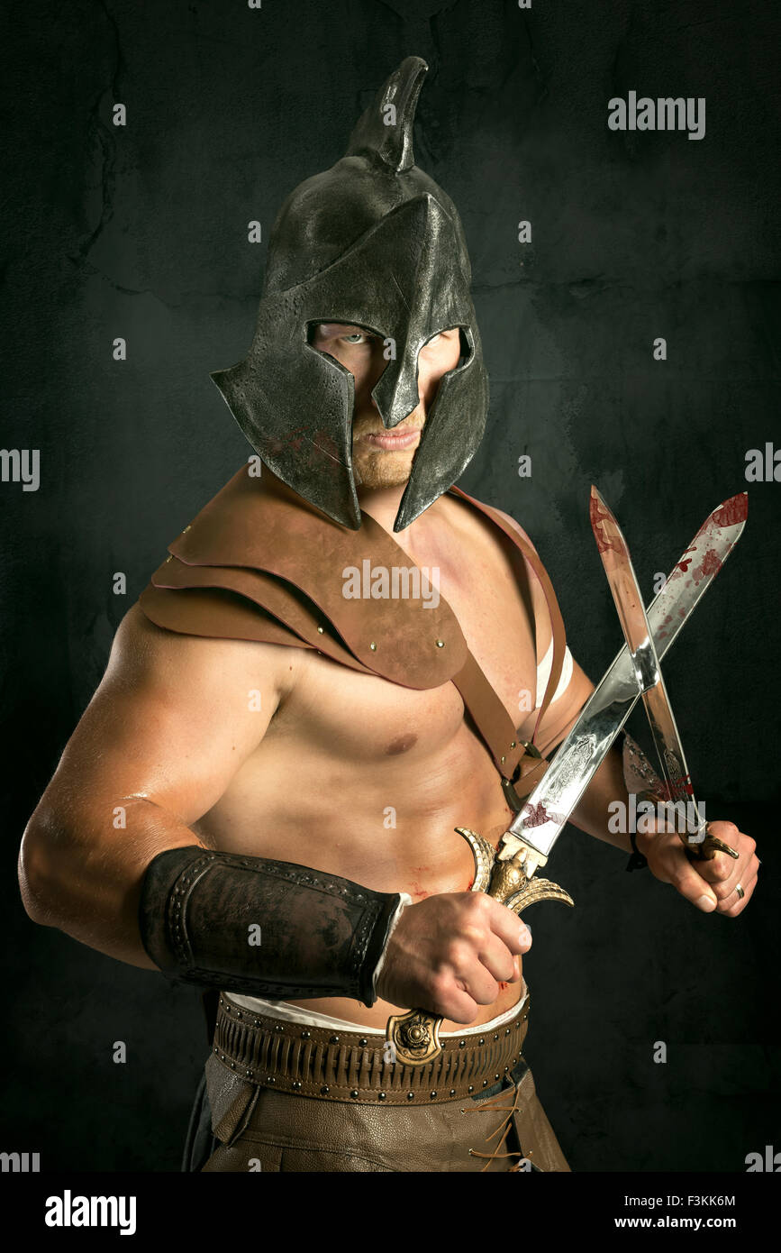 Gladiator posing isolated in a dark background Stock Photo - Alamy