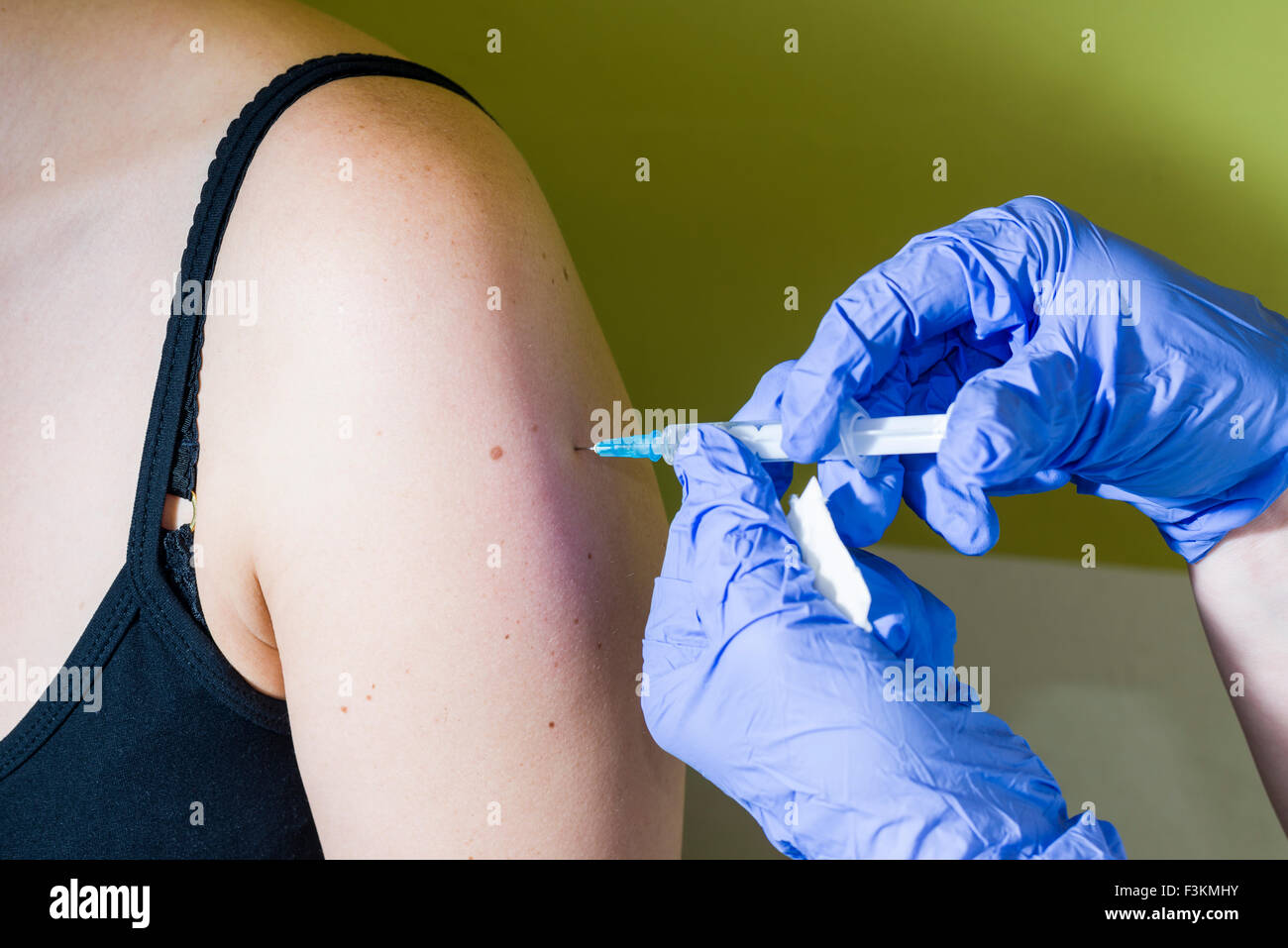 A injection of fluid medicine into a patients arm is done by two hands ...