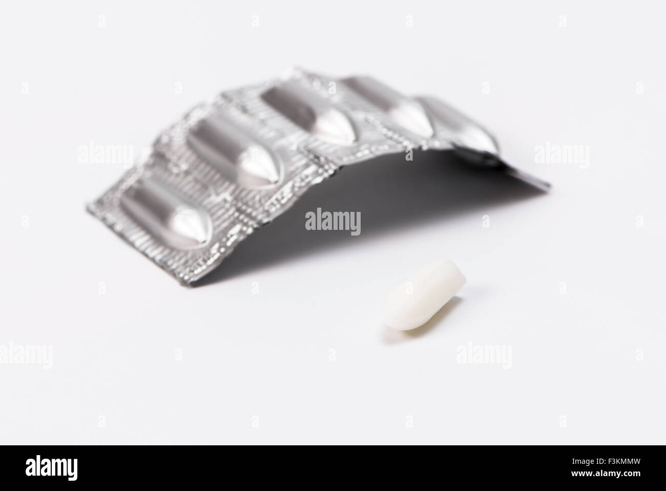 A silverish package with medicine suppository, one unpacked, displayed ...