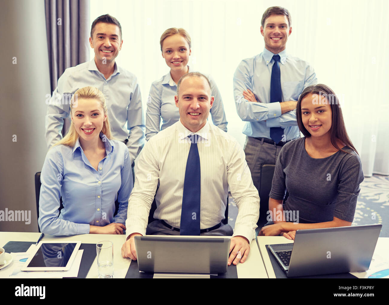smiling business people with laptop in office Stock Photo - Alamy