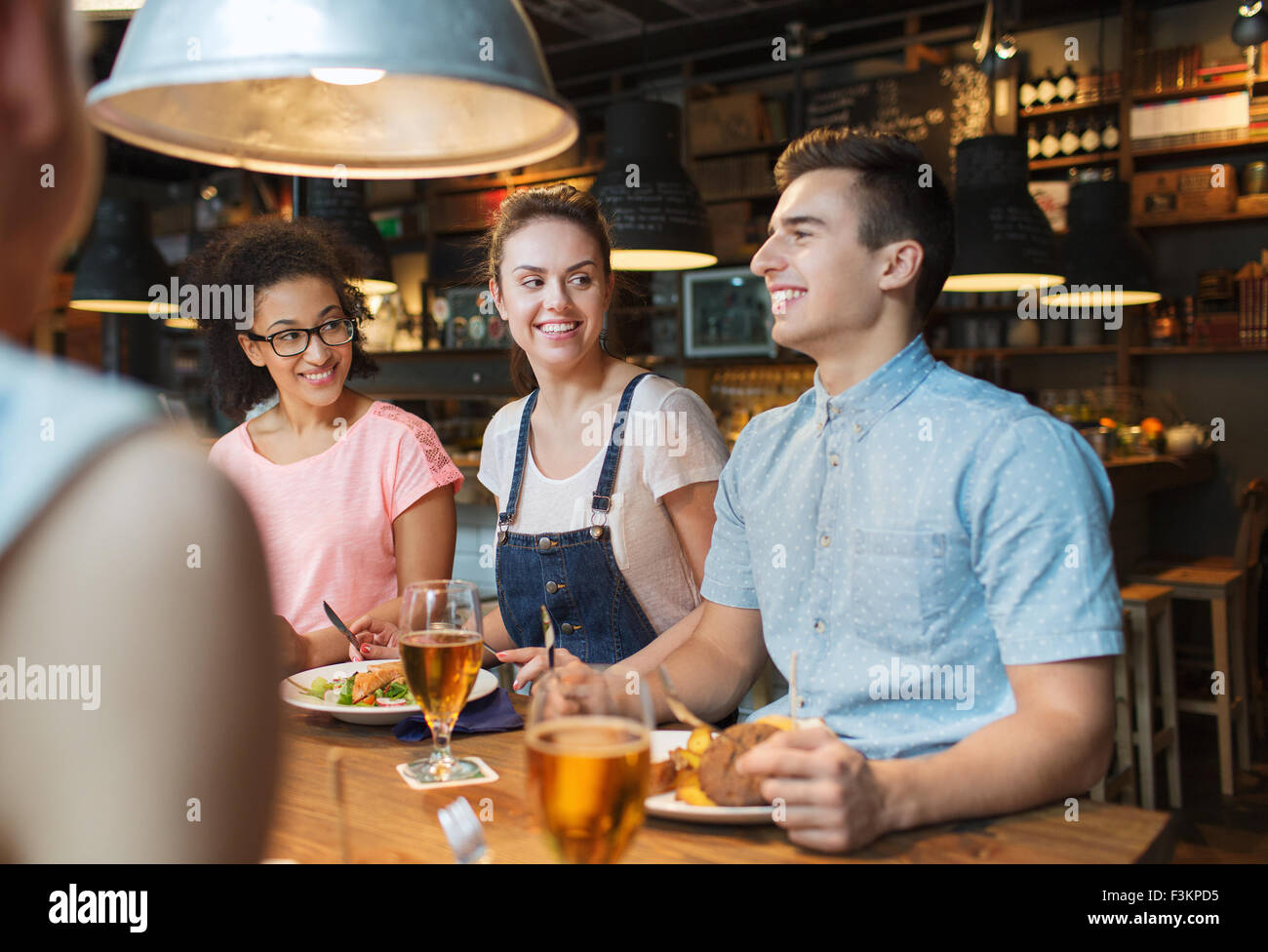 happy friends eating and drinking at bar or pub Stock Photo - Alamy
