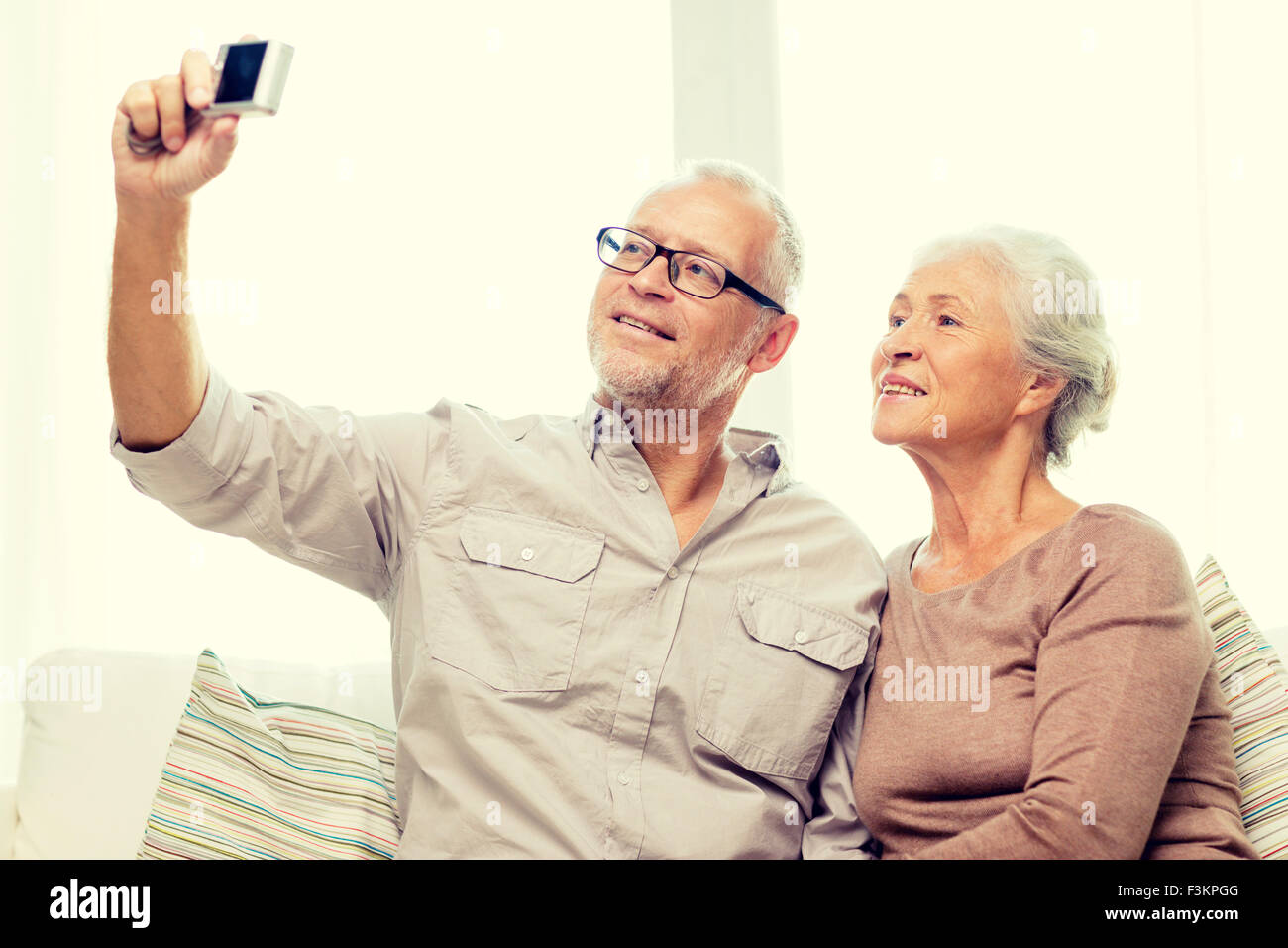 happy senior couple with camera at home Stock Photo - Alamy
