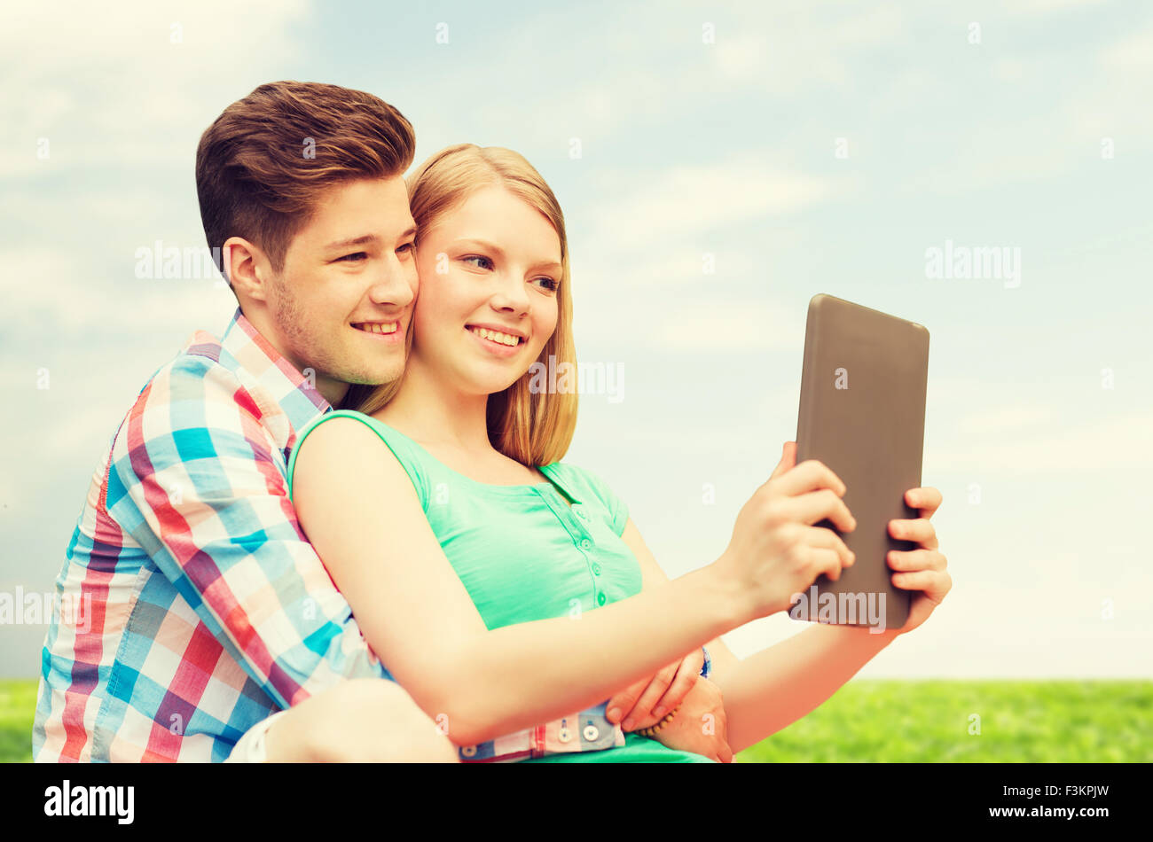 happy couple with tablet pc taking selfie outdoors Stock Photo - Alamy