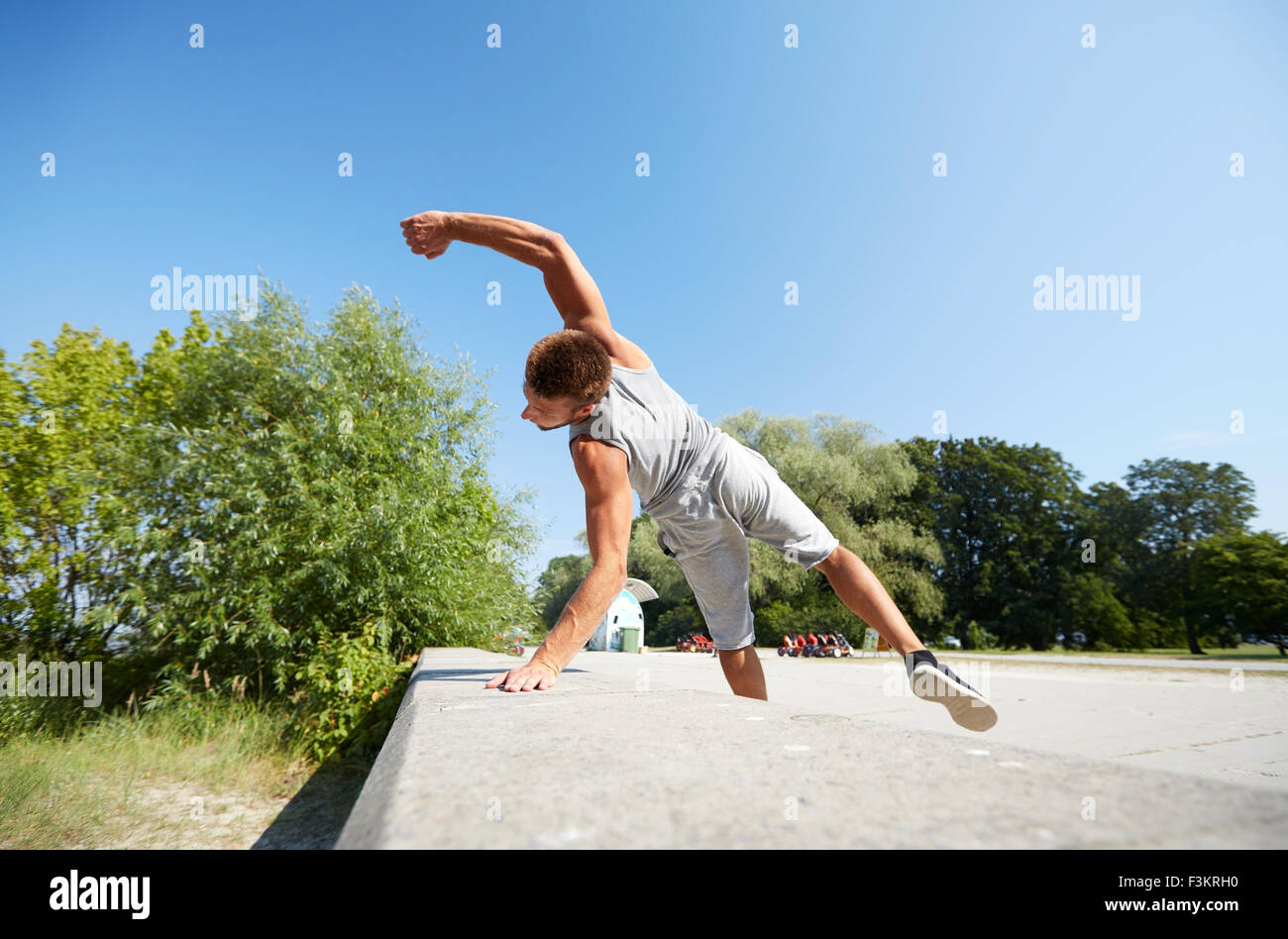 sporty young man jumping in summer park Stock Photo - Alamy