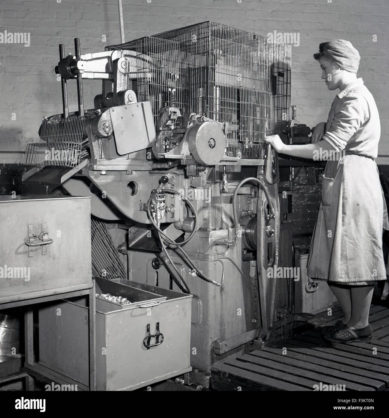 Historical, 1950s, adult female operative using a large machine at the ...