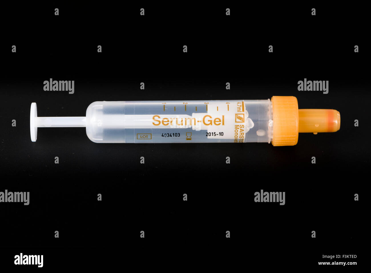 An orange pharmaceutical phial for medical use, displayed on a black ...
