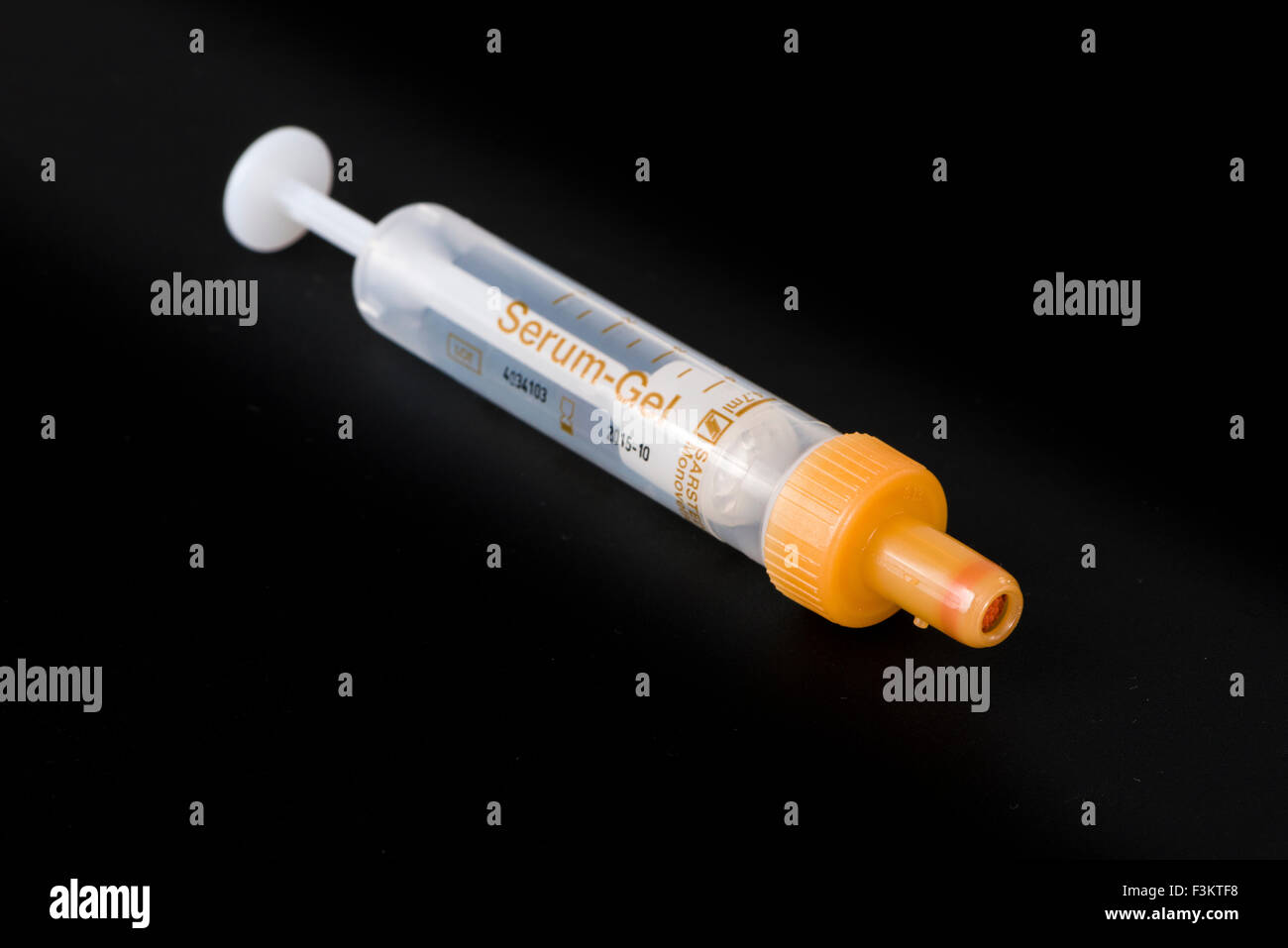 An orange pharmaceutical phial for medical use, displayed on a black ...