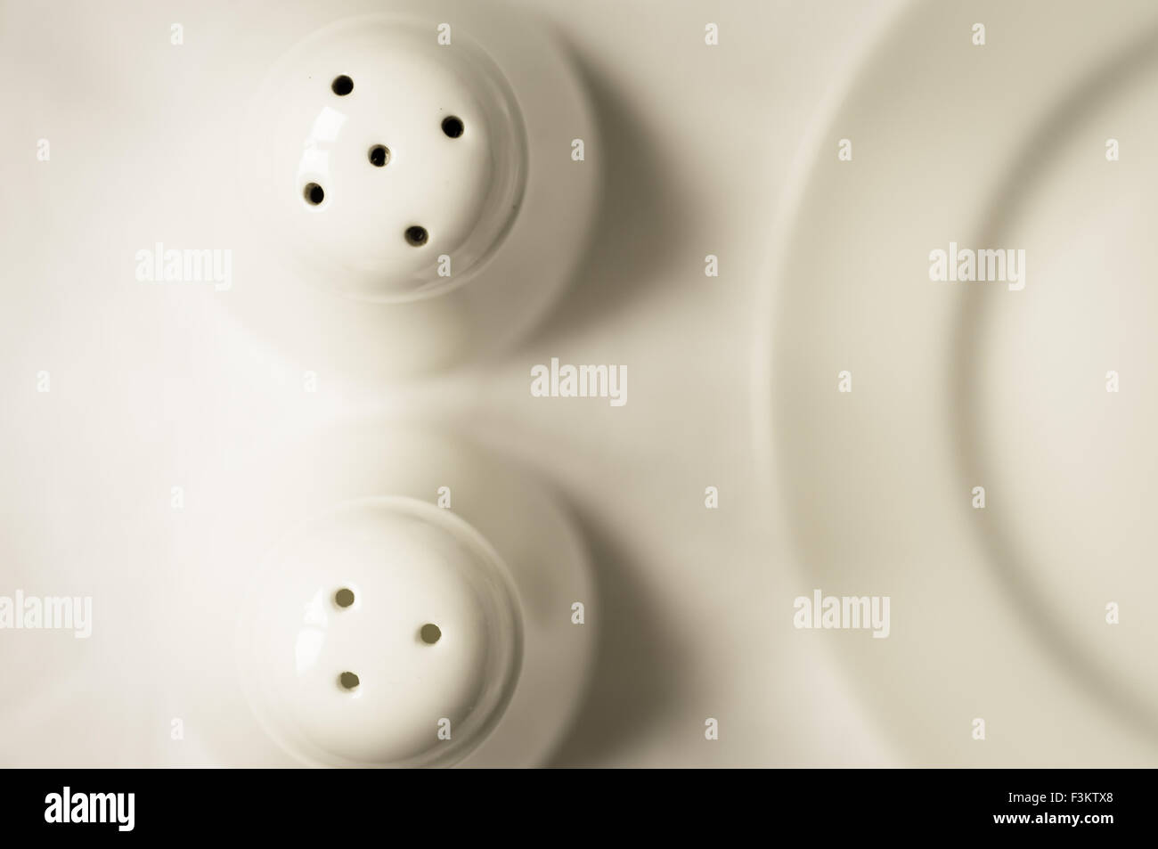 Salt and pepper shakers with a plate on the table top view Stock Photo ...
