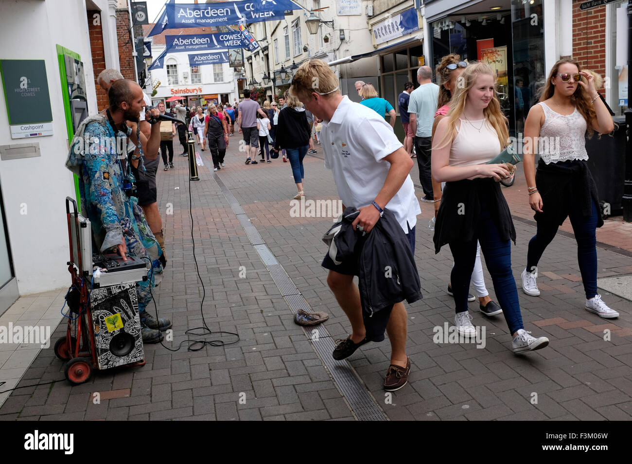 Busker The high Street people dropping money into hat shopping Yacht ...
